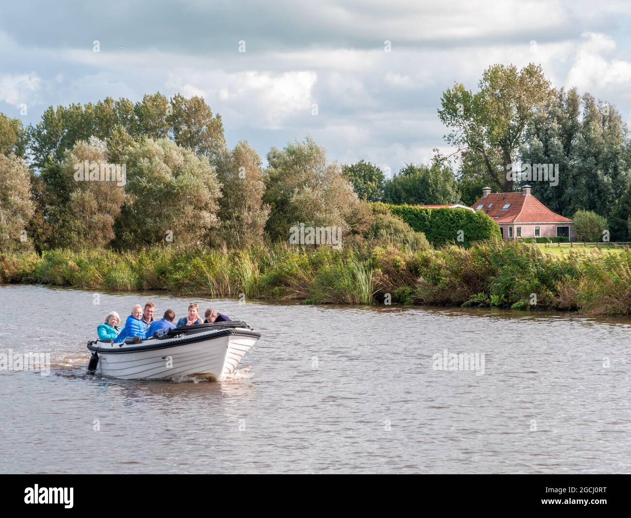 Group of people cruising in small sloop boat on canal near Grouw in ...