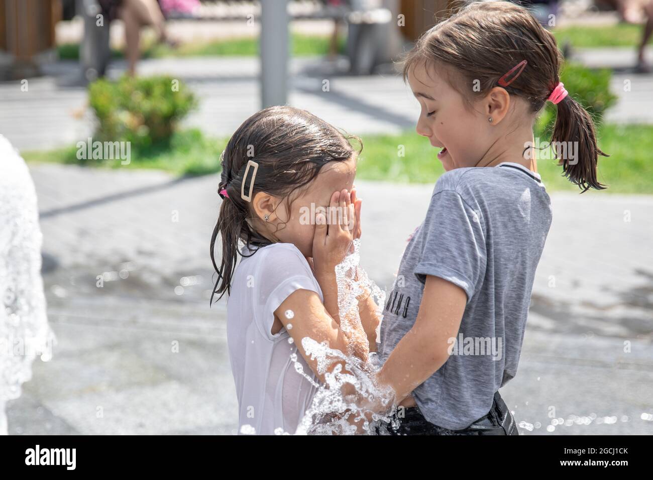 Little girls cool off in a fountain on a hot summer day Stock Photo - Alamy