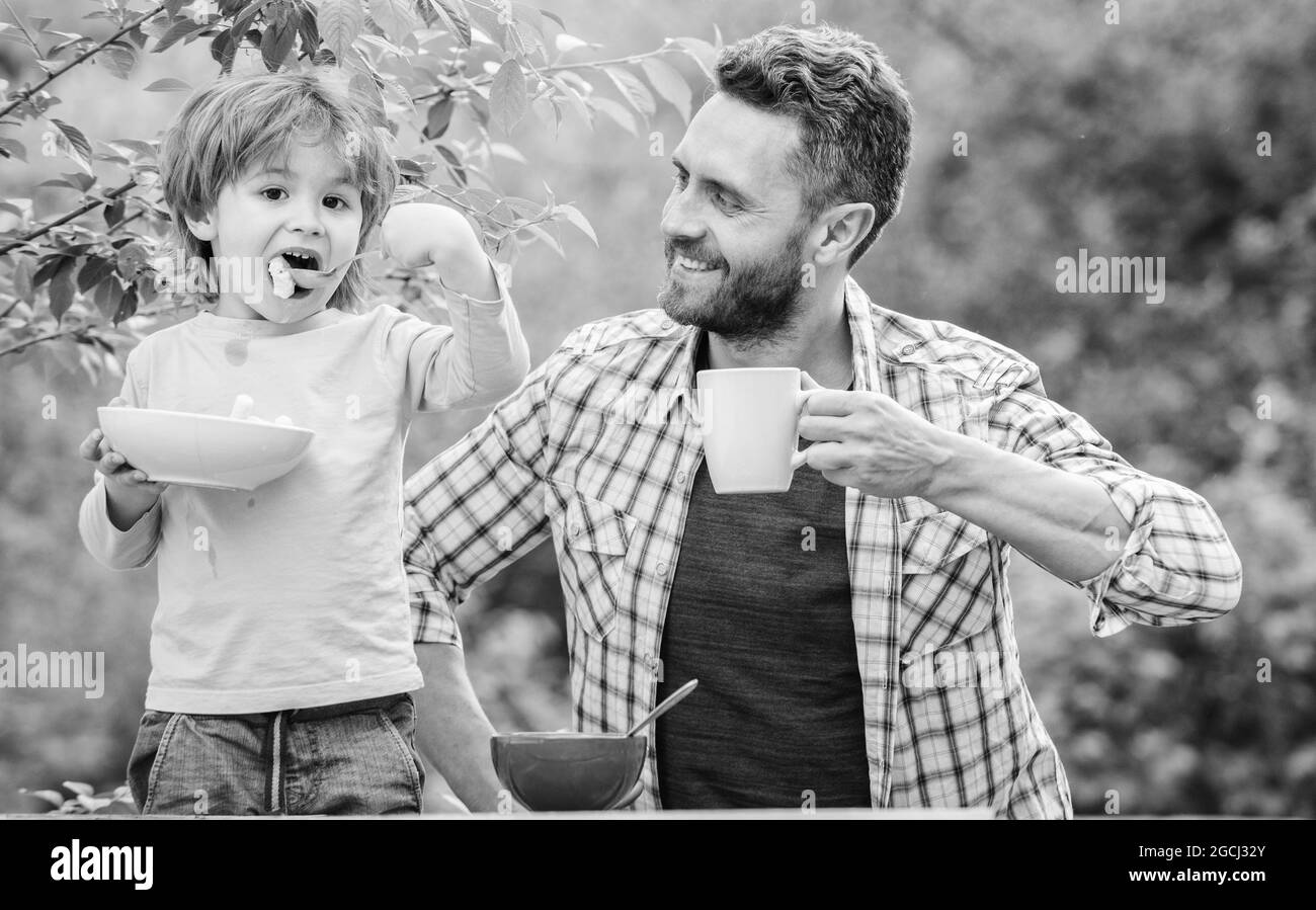 Healthy breakfast. Father son eat food and have fun. Little boy and dad ...