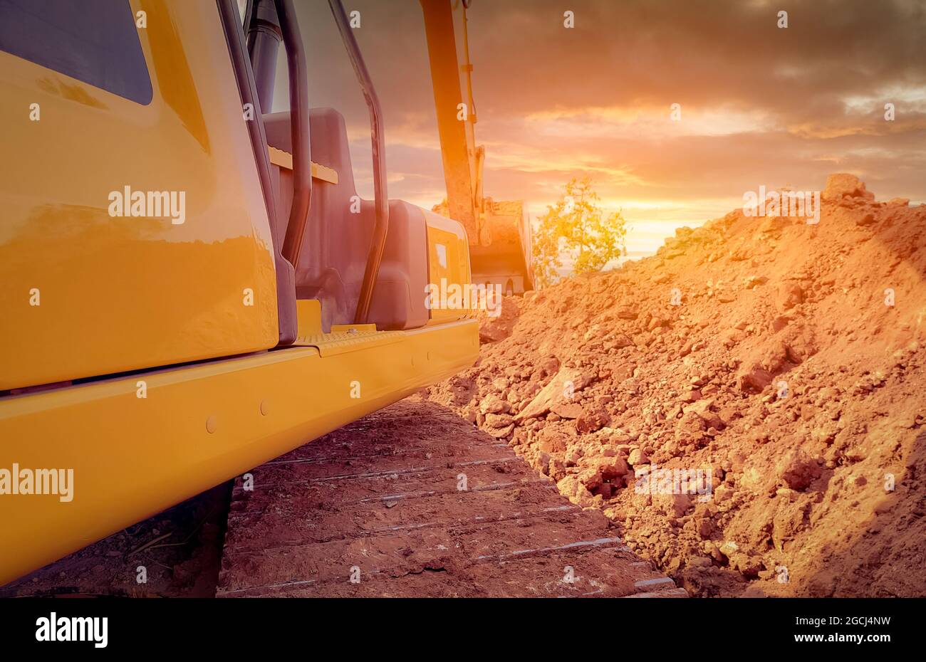 Back view backhoe working by digging soil at the construction site ...
