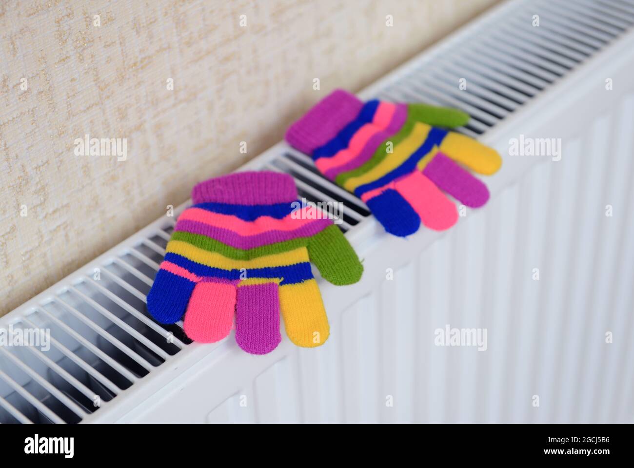 Knitted gloves drying on heating radiator Stock Photo - Alamy