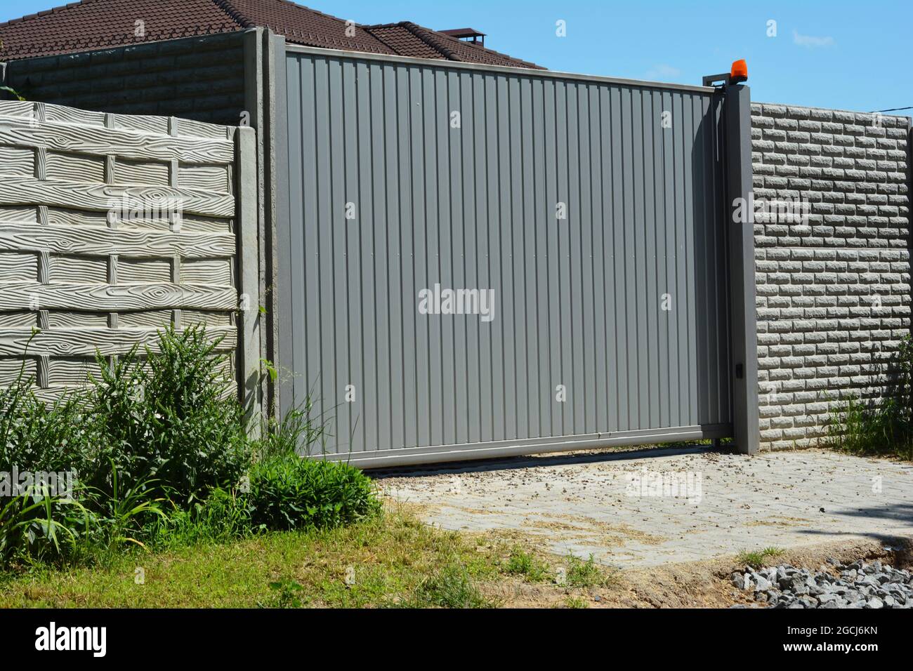A close-up of a gray metal sliding automatic gate, sliding driveway ...