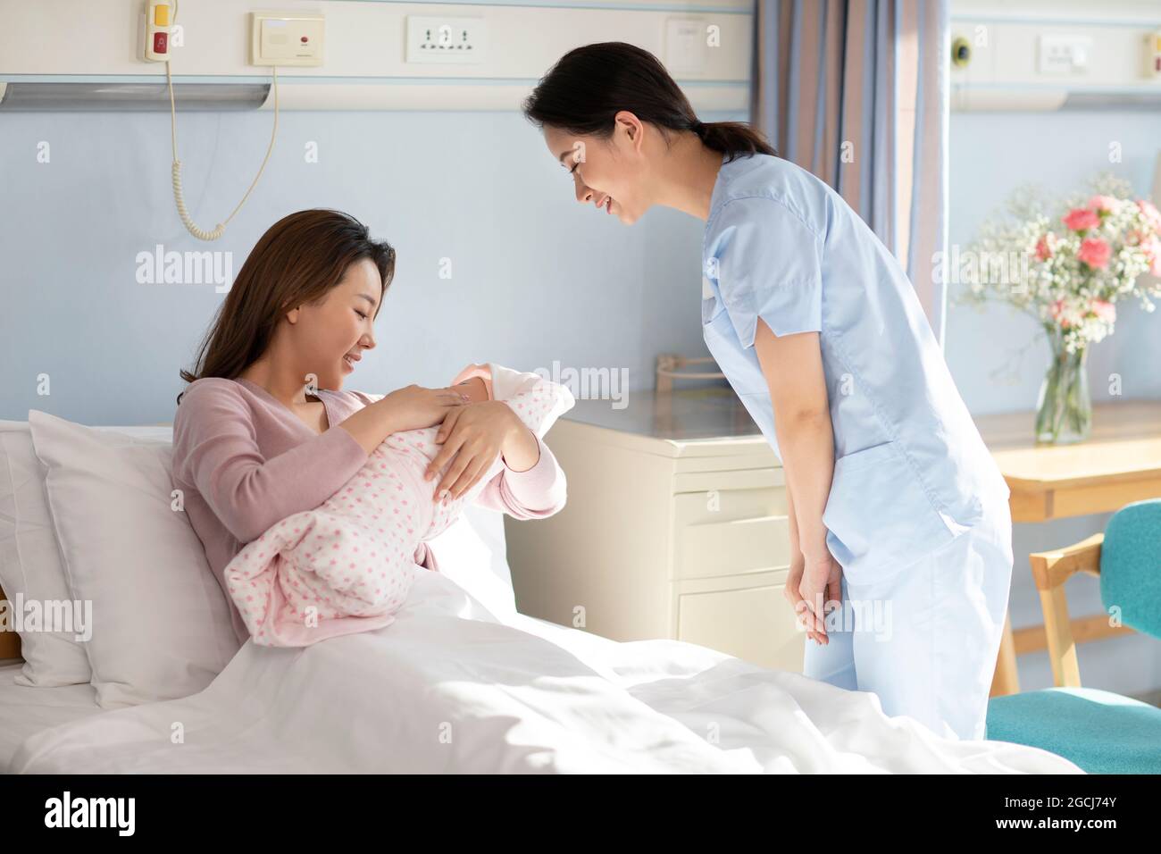Young mother holding newborn baby in hospital ward Stock Photo - Alamy