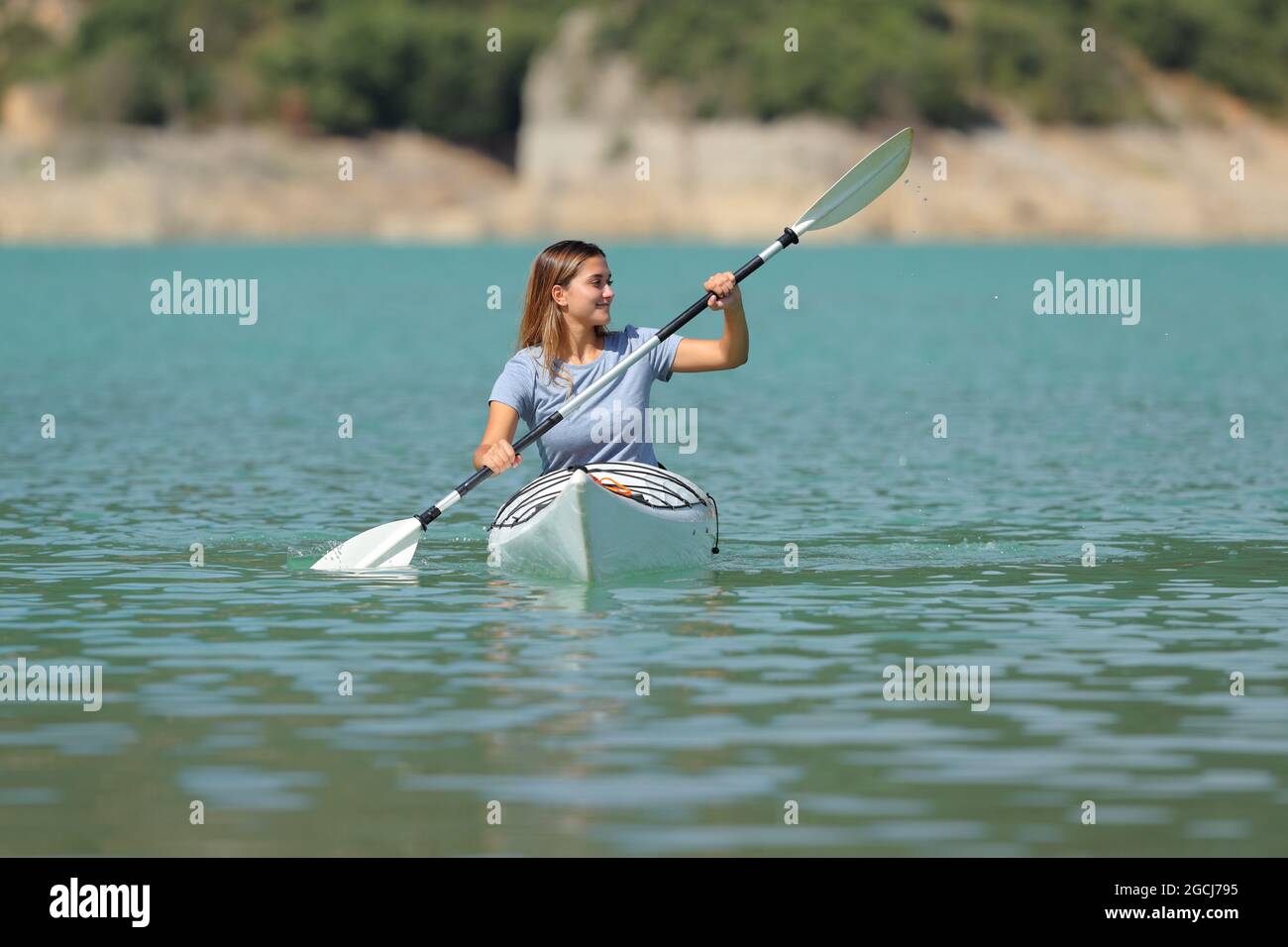 Happy woman rowing in a kayak looking at side in a beautiful lake Stock ...