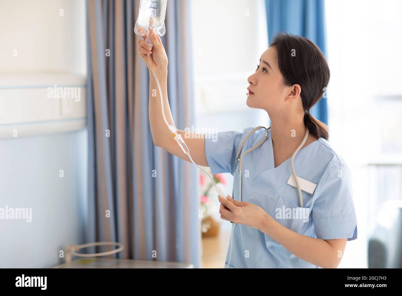 Young nurse checking IV drip in hospital ward Stock Photo - Alamy