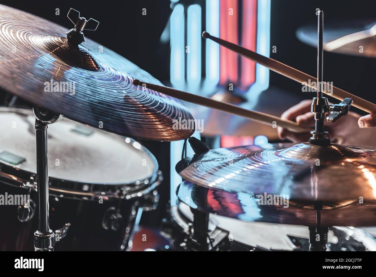 Close-up of drum cymbals as the drummer plays with beautiful lighting ...