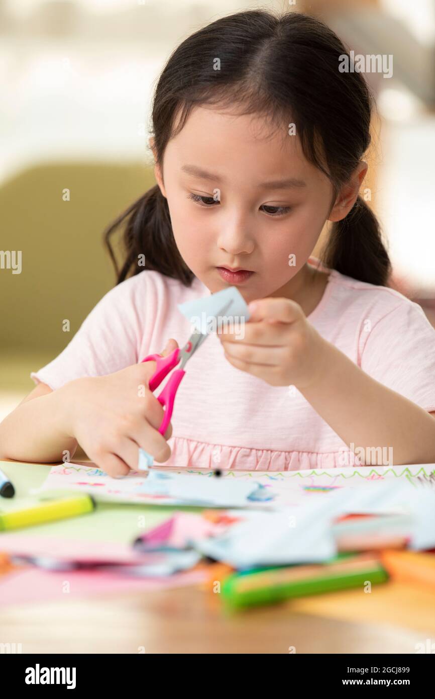 Little girl cutting paper at home Stock Photo - Alamy