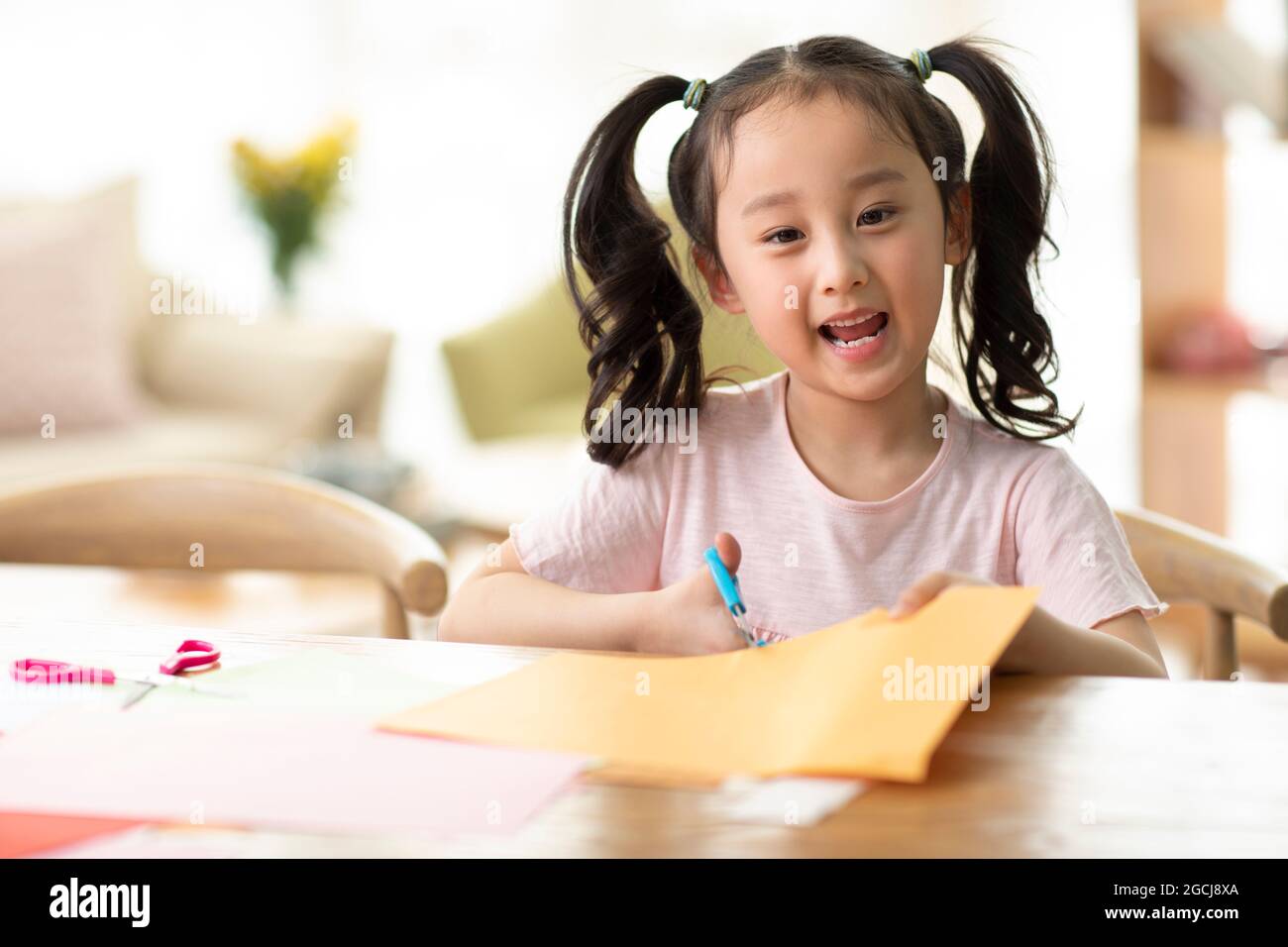 Little girl cutting paper at home Stock Photo - Alamy