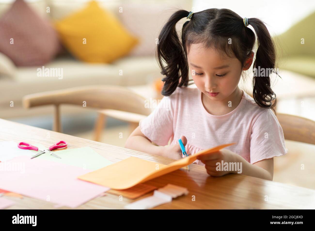 Little girl cutting paper at home Stock Photo - Alamy