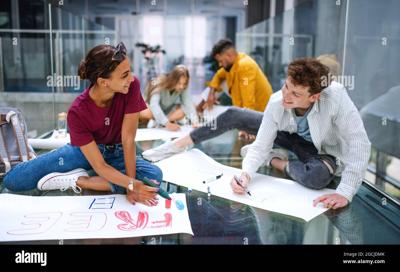 University students activists making banners for protest indoors ...