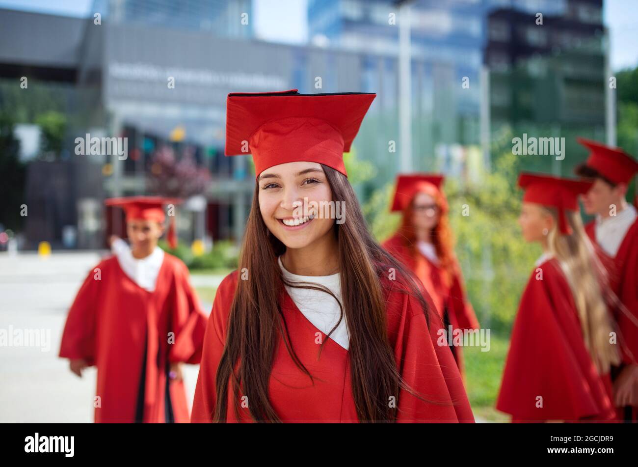 Portrait of cheerful university student celebrating outdoors ...