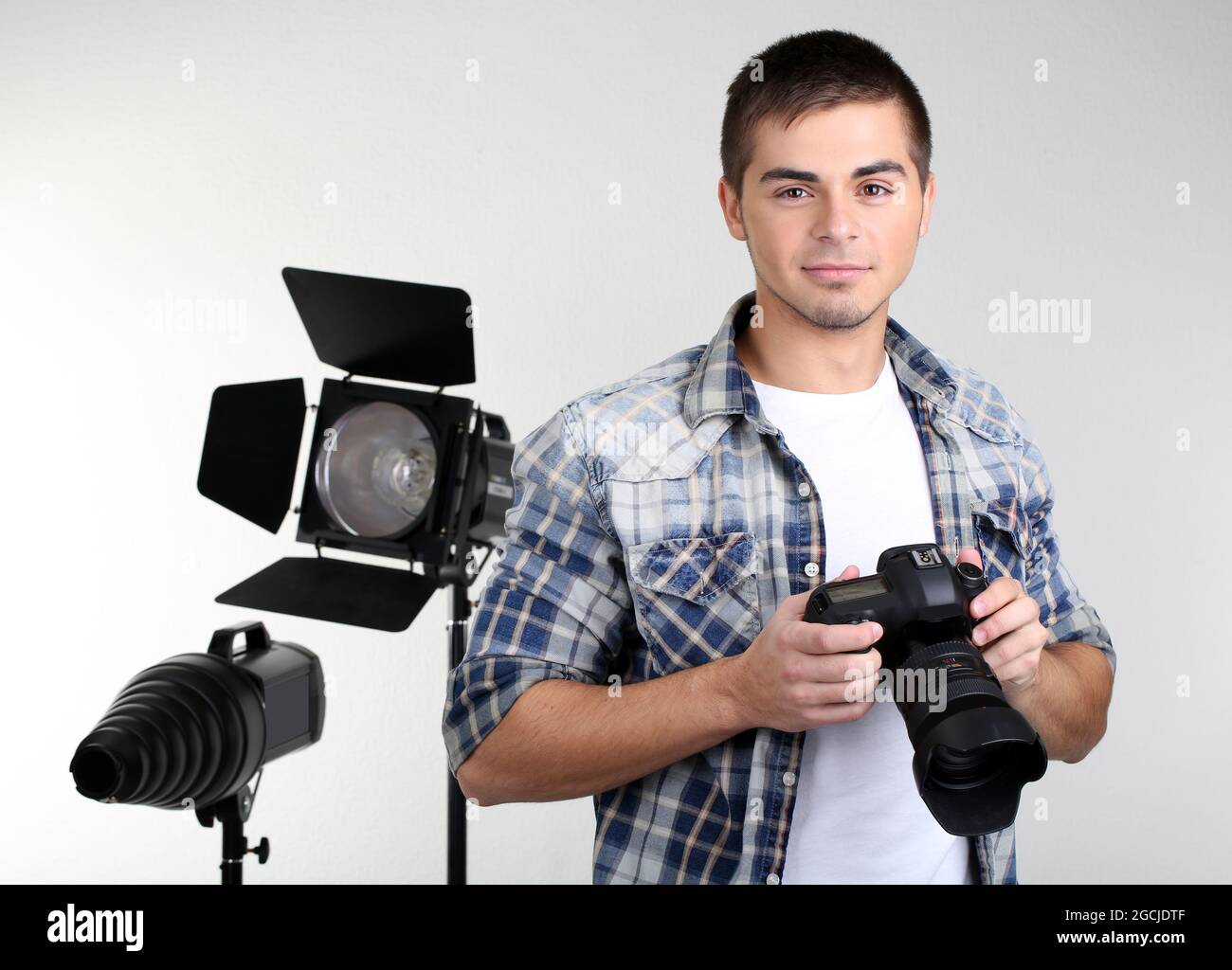 Handsome photographer with camera, on photo studio background Stock ...