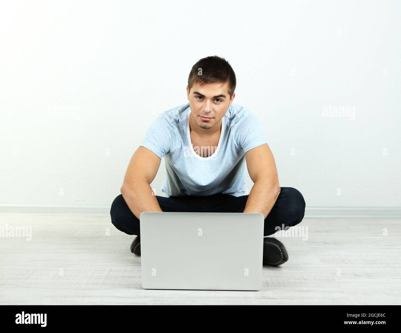 Guy sitting on floor in room Stock Photo - Alamy