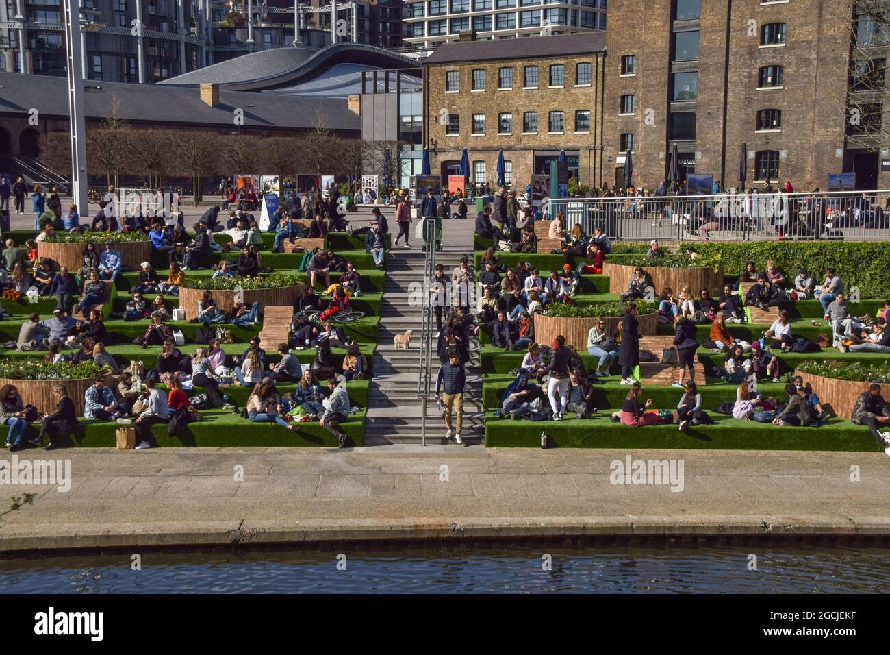 People sitting on the steps at Granary Square in King's Cross. London ...