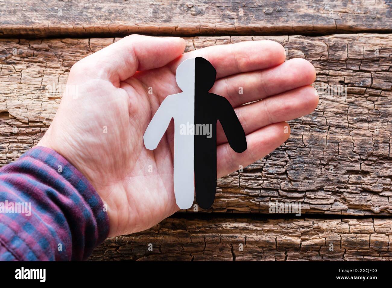 black and white silhouette in hand on a wooden background. anti-racism ...