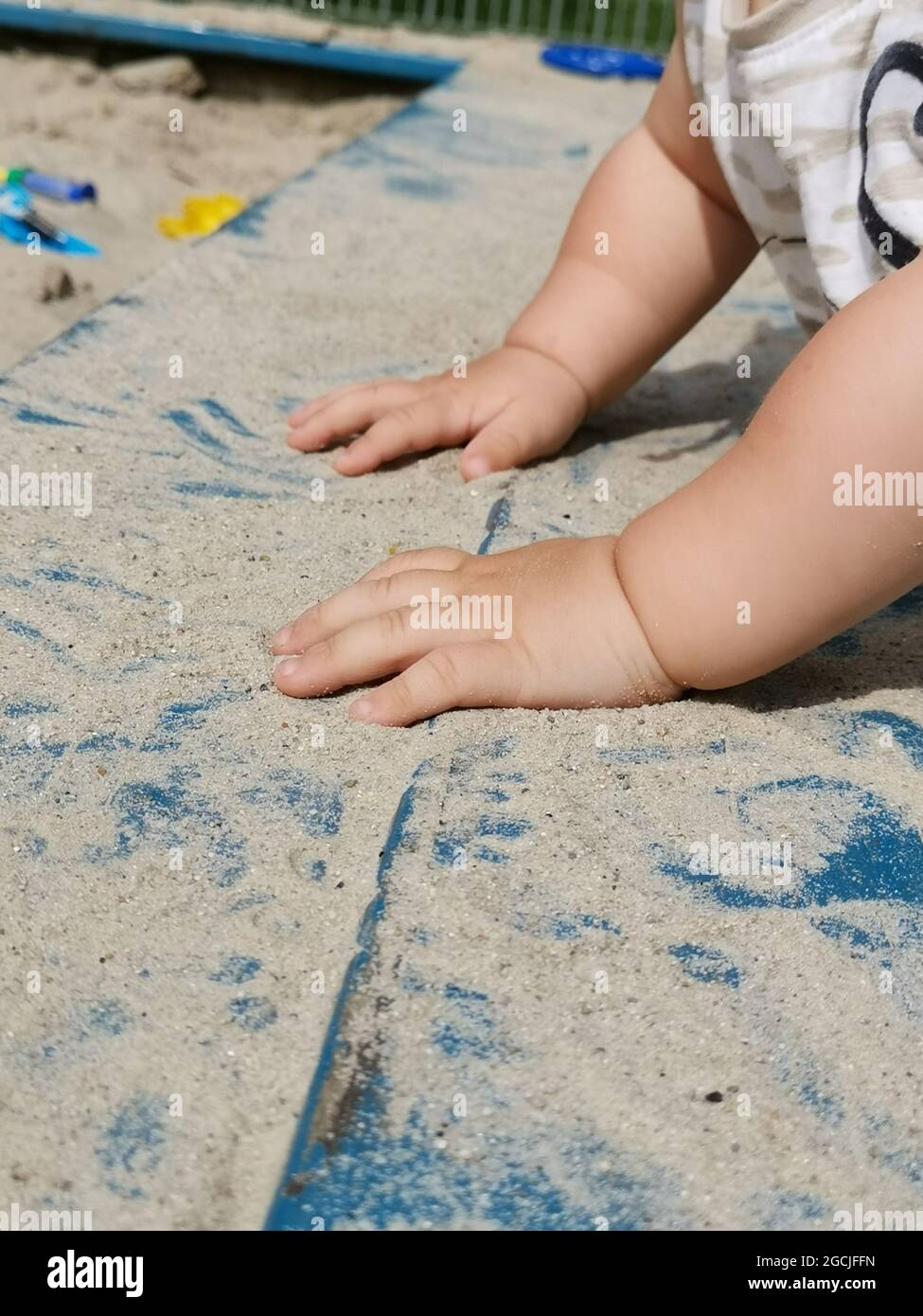 Hands of a baby playing in a sandbox Stock Photo - Alamy