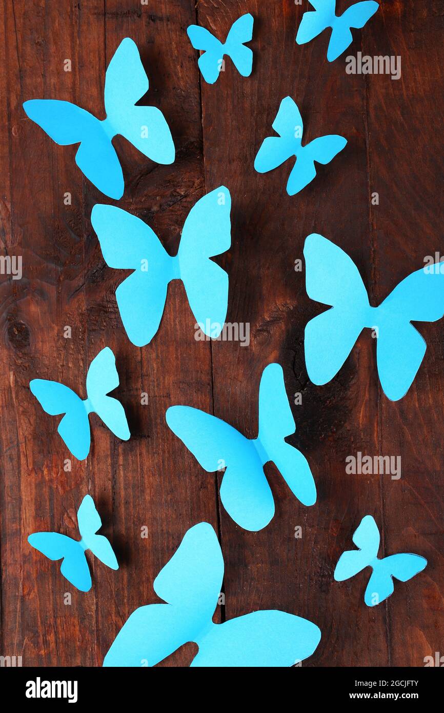 Paper blue butterflies on wooden board background Stock Photo - Alamy