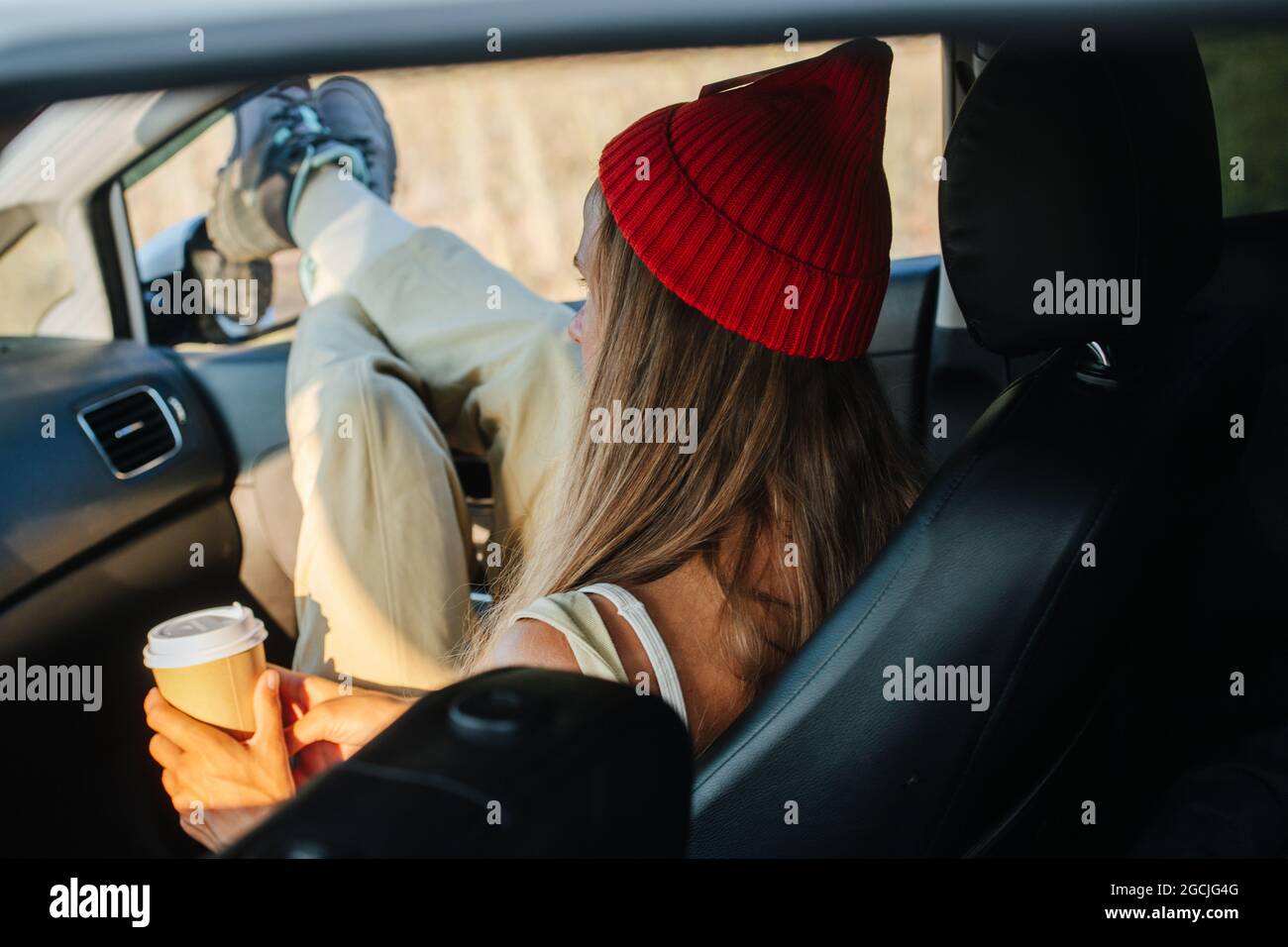 Girl in a colorful watch cap chilling in the car, enjoying views ...