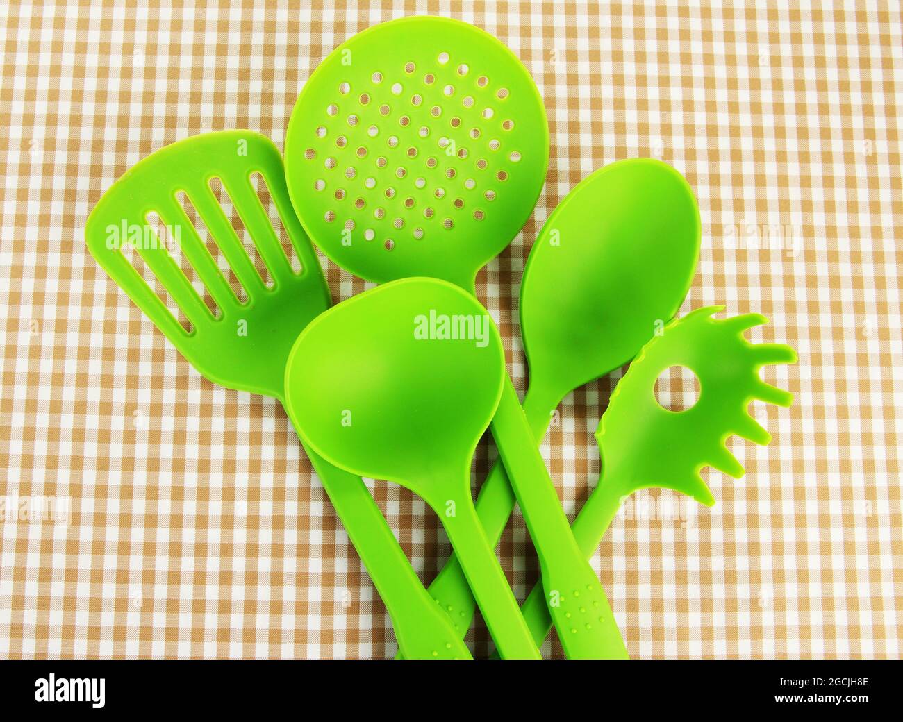 Plastic kitchen utensils on fabric background Stock Photo - Alamy