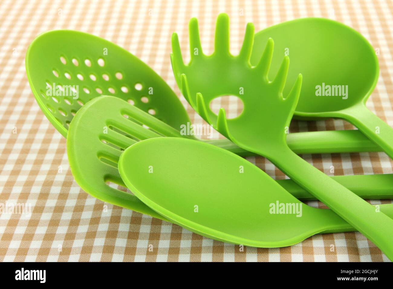 Plastic kitchen utensils on fabric background Stock Photo - Alamy