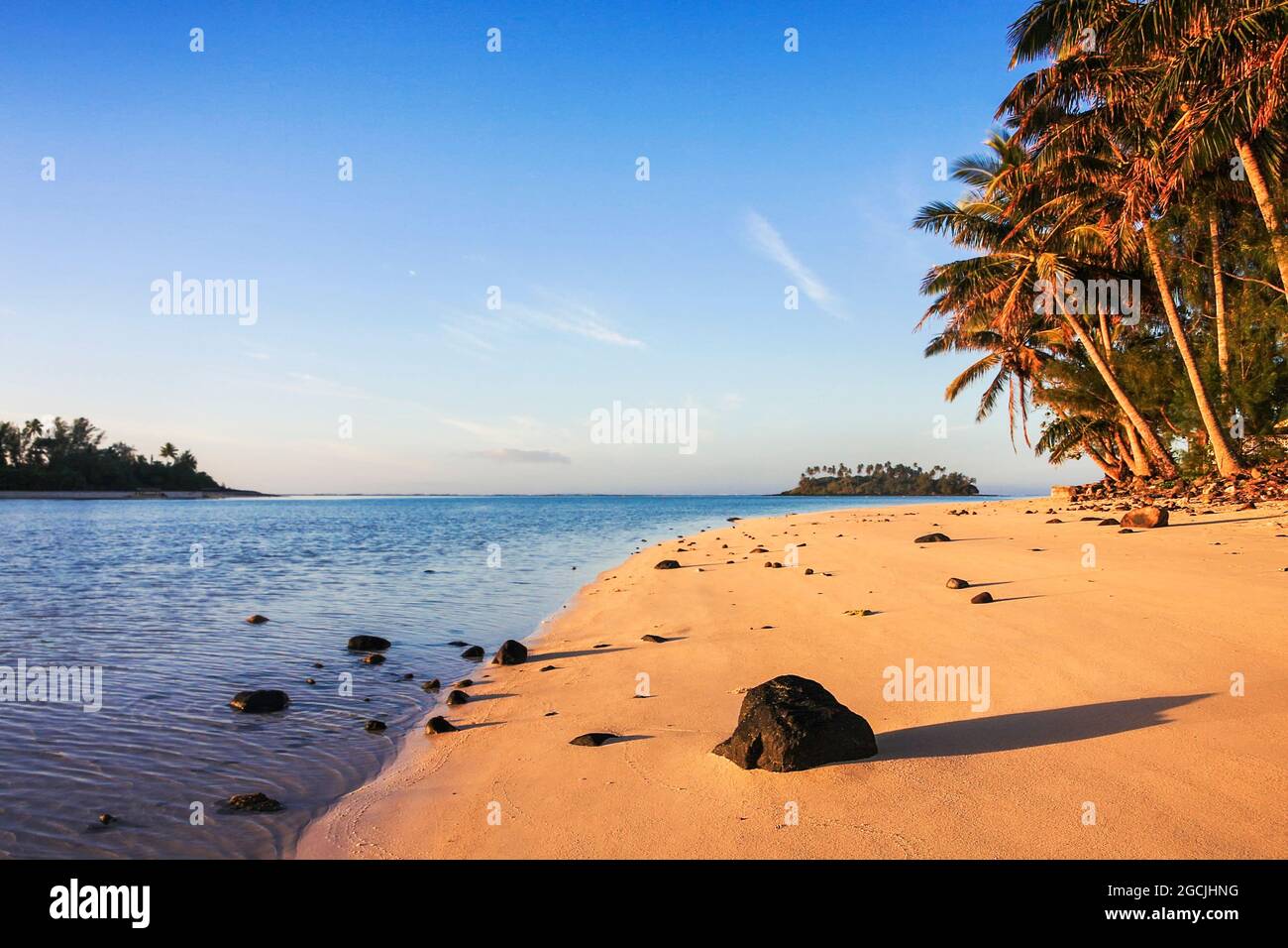 a sandy beach next to a body of water in cook islands Stock Photo - Alamy