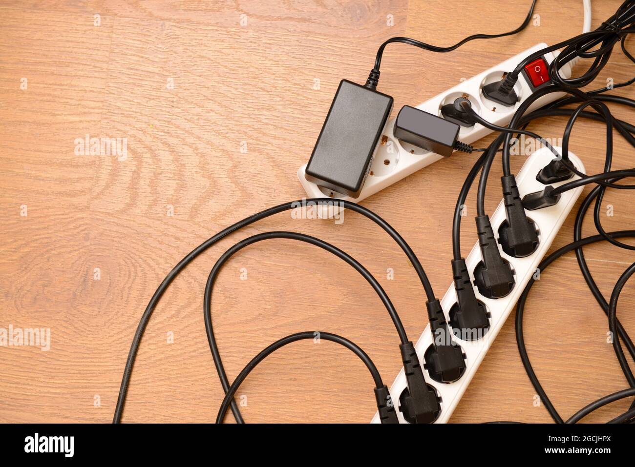 Overloaded power boards, on wooden floor background Stock Photo - Alamy