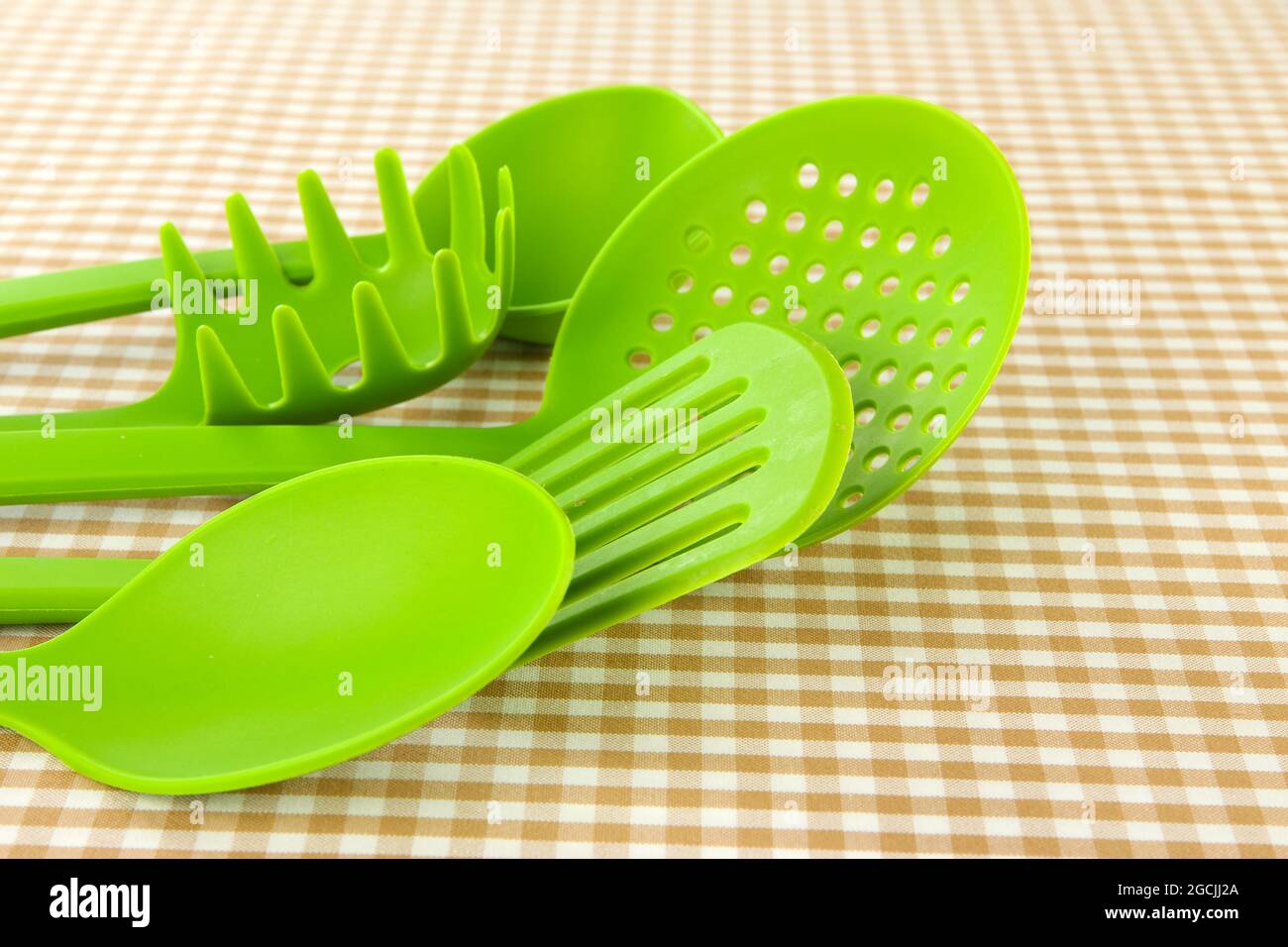 Plastic kitchen utensils on fabric background Stock Photo - Alamy