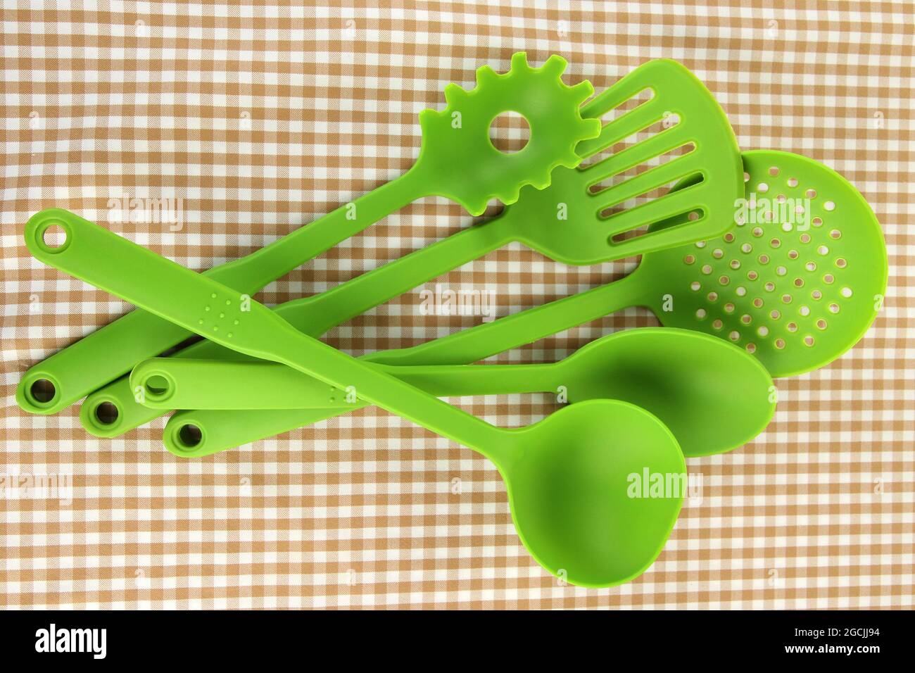 Plastic kitchen utensils on fabric background Stock Photo - Alamy