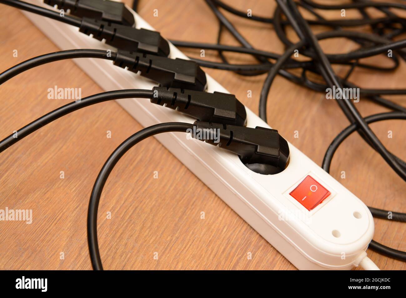 Overloaded power boards, on wooden floor background Stock Photo - Alamy