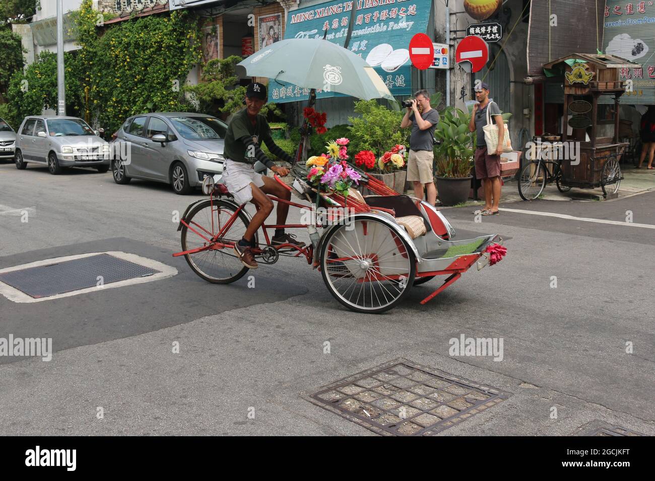 Closeup shot of colorful bicycle, trishaw with umbrellas on a street in ...