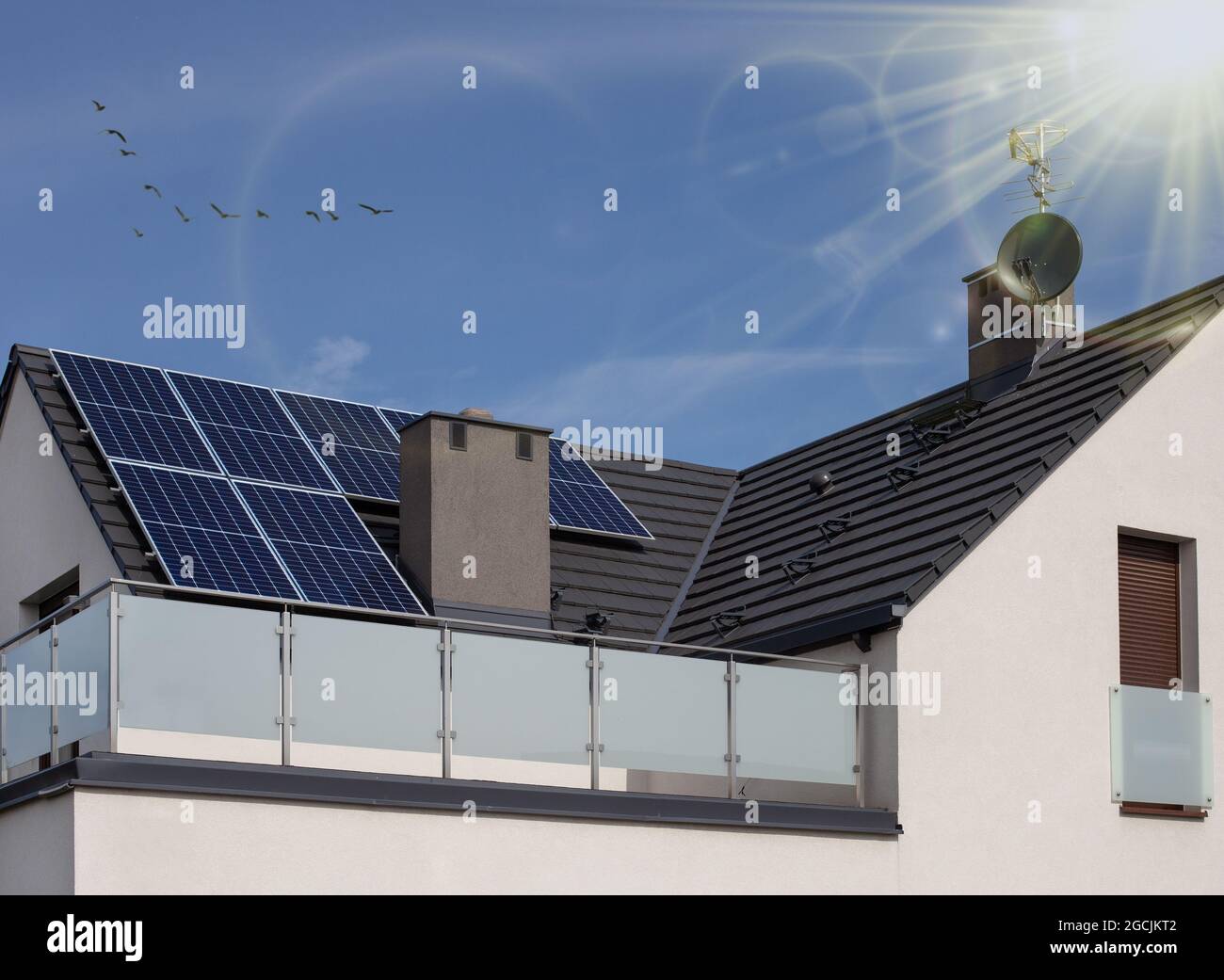 Solar Panel on a dark gable roof - blue sky and sun. Moder house Stock ...