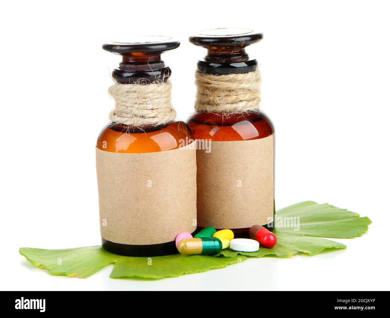 Ginkgo biloba leaves and medicine bottles with pills isolated on white ...