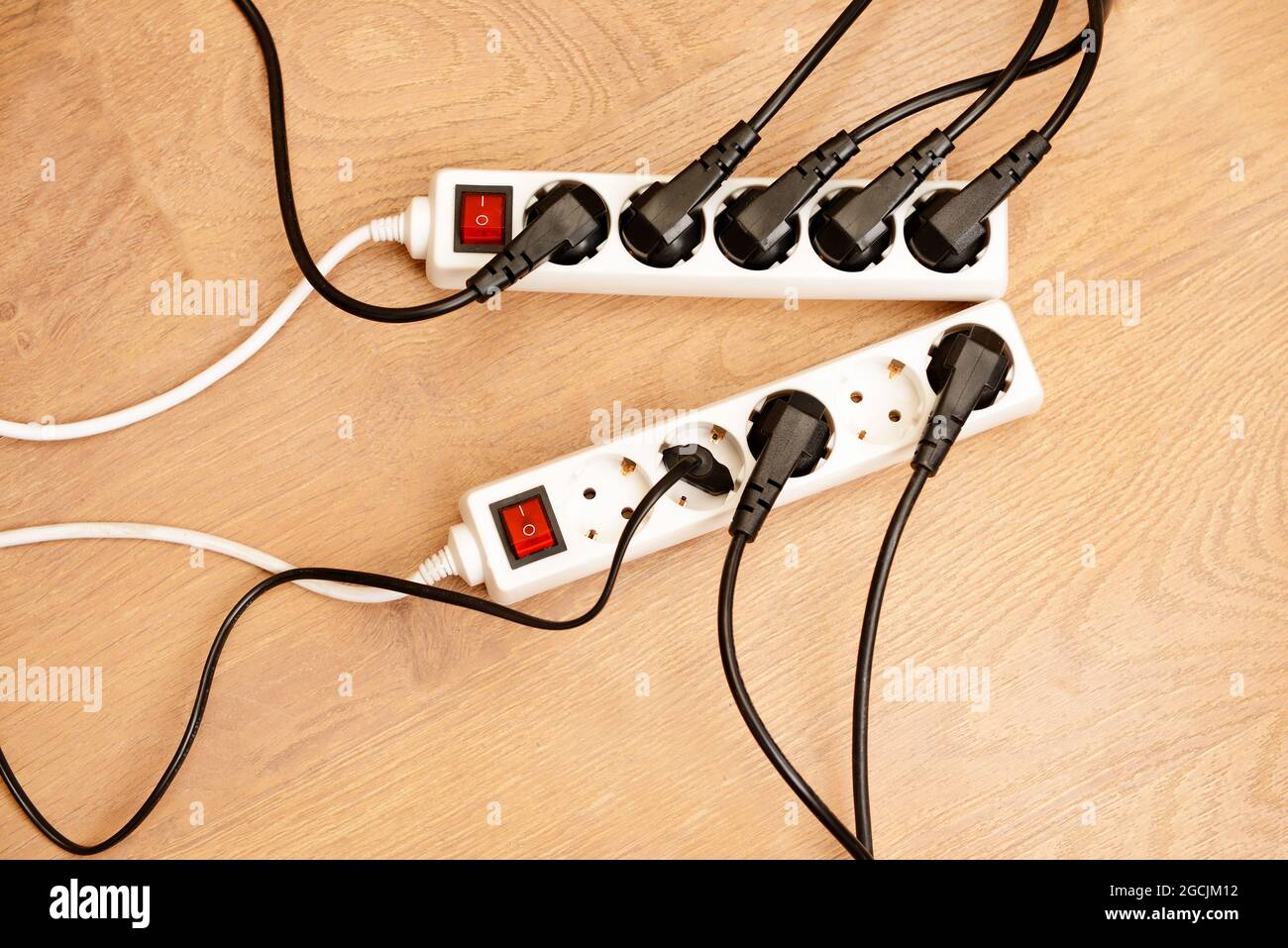 Overloaded power boards, on wooden floor background Stock Photo - Alamy