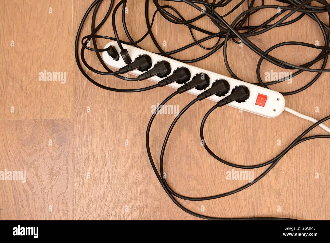 Overloaded power boards, on wooden floor background Stock Photo - Alamy