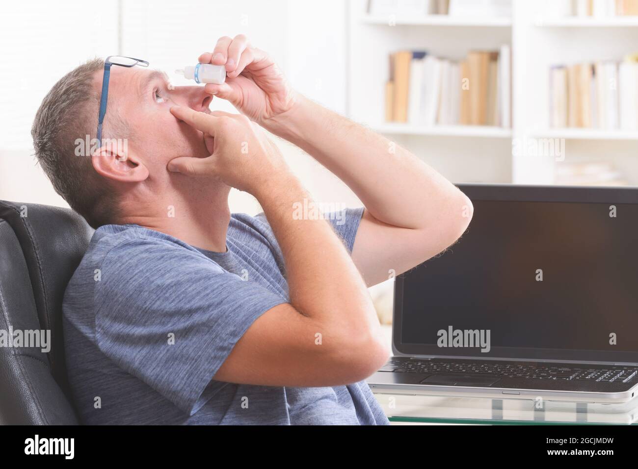 Man applying eye drops after a long sitting at computer Stock Photo - Alamy