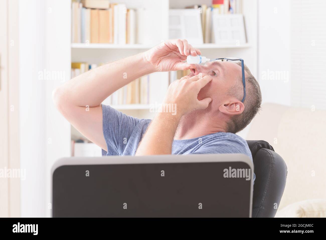 Man applying eye drops after a long sitting at computer Stock Photo - Alamy
