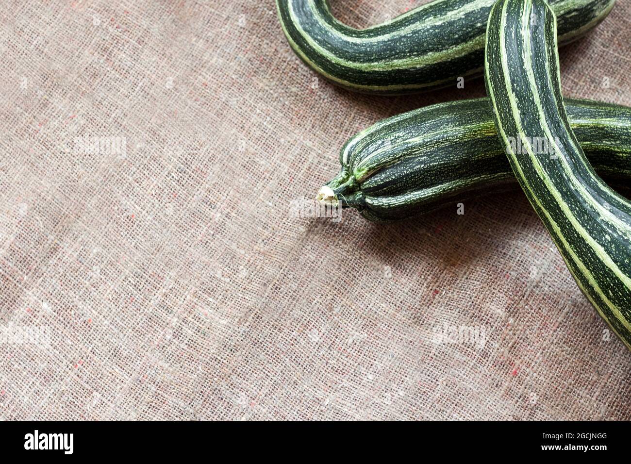 Fresh striped zucchini on sackcloth background with copy space Stock ...