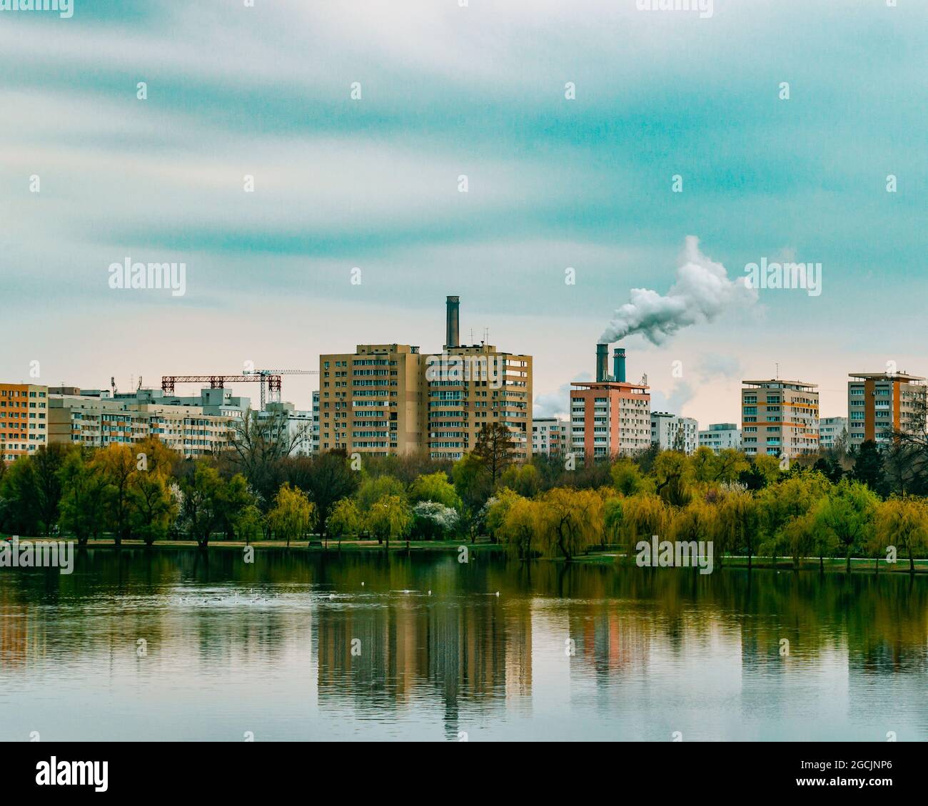 Urban pond surrounded by beautiful landscapes with high rise industrial ...