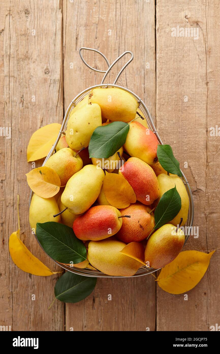 Pears in pear shape metal fruit basket Stock Photo - Alamy