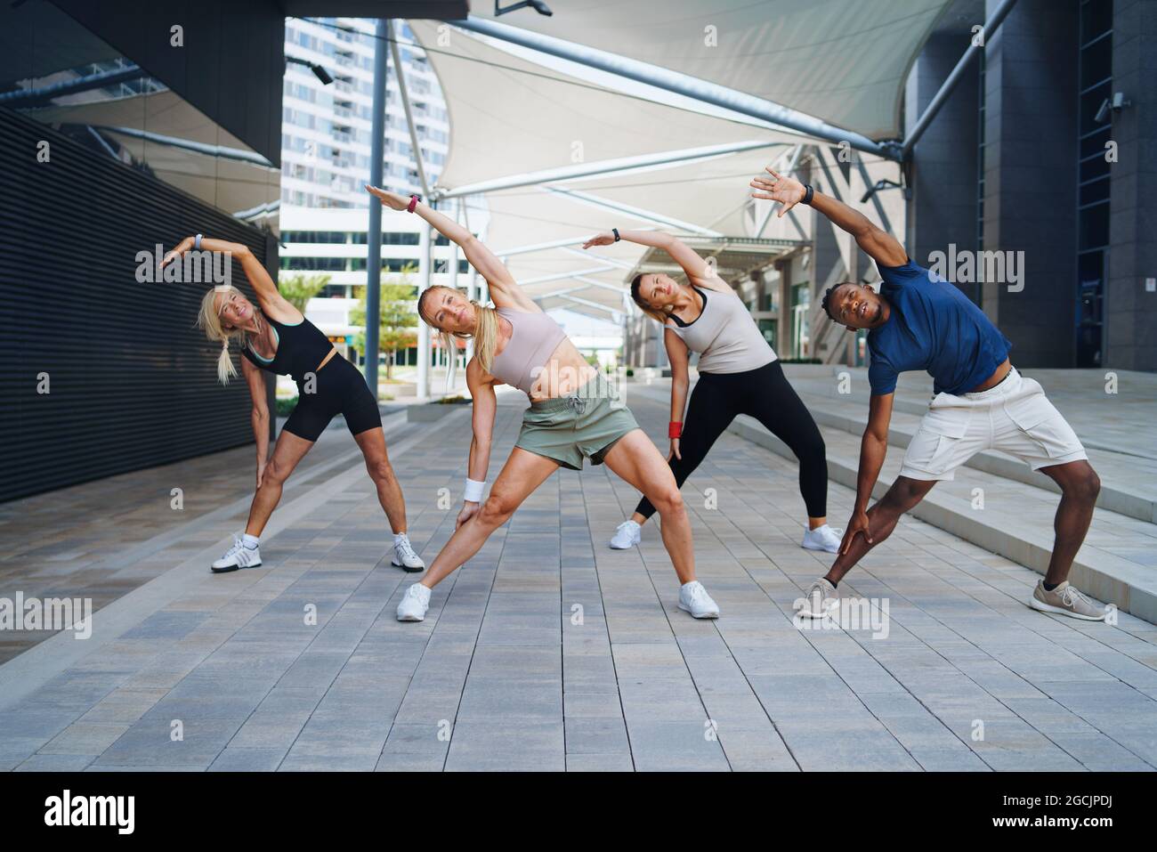 Group of young and old people doing exercise outdoors in city Stock ...