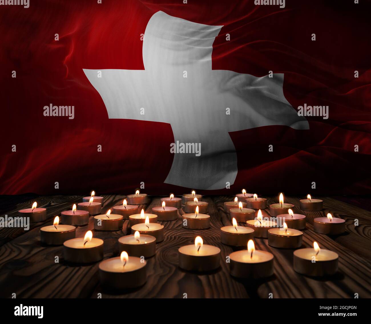 Mourning candles burning on Switzerland national flag of background ...
