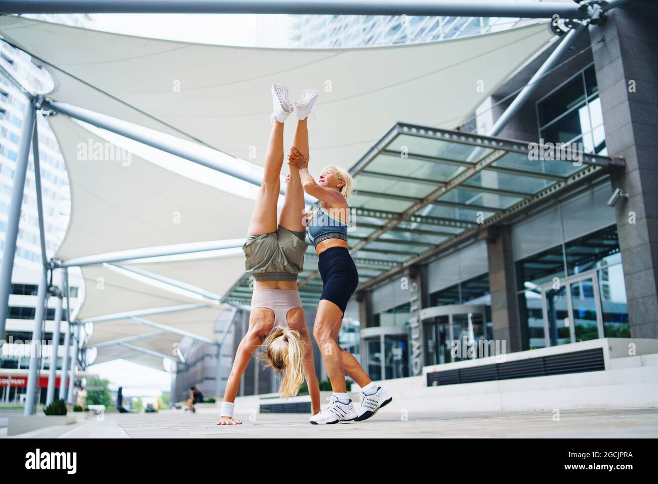 Two women doing exercise outdoors in city, healthy lifestyle concept ...