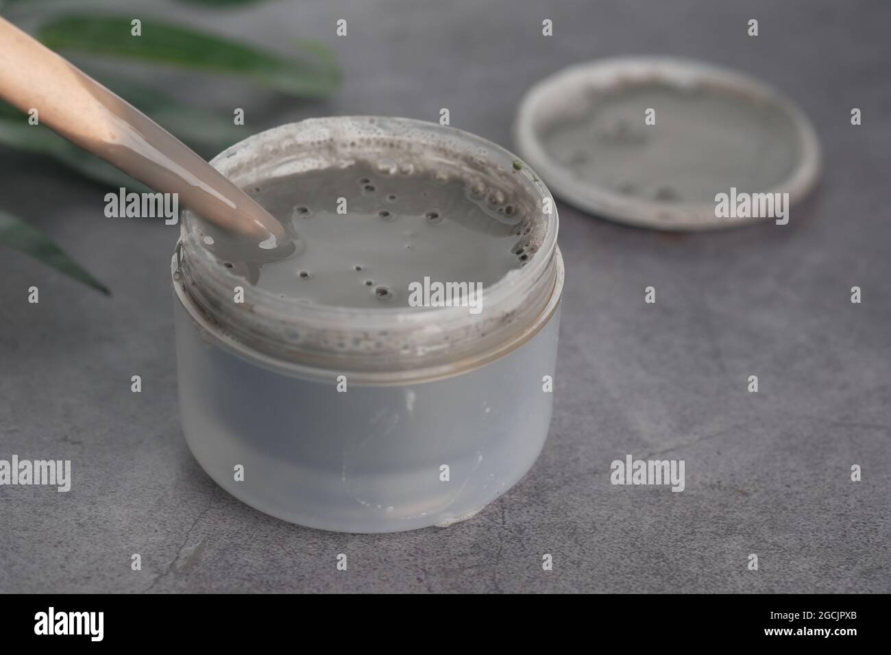 bubble clay mask in container on black background Stock Photo - Alamy