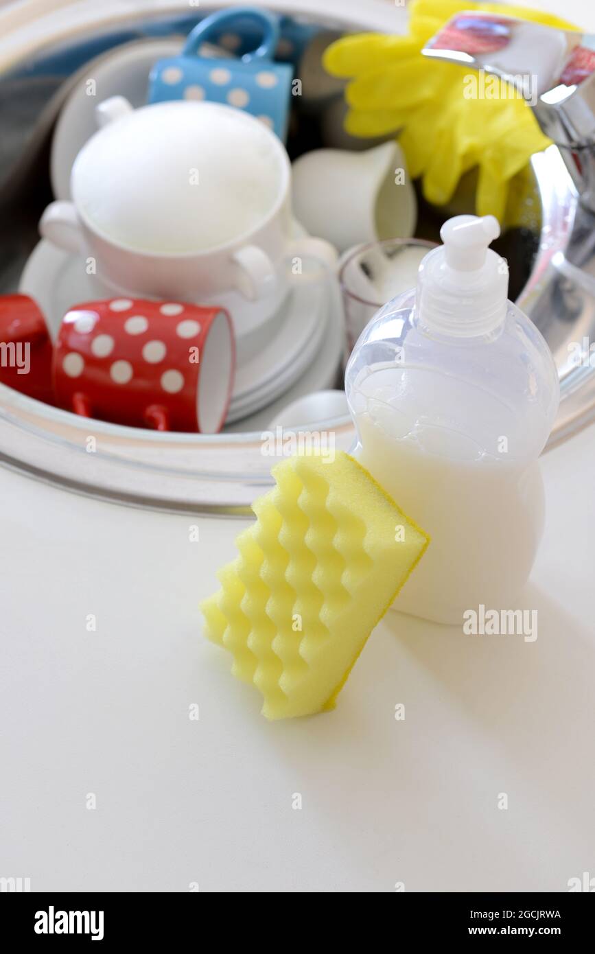 Stack of dishes soaking in kitchen sink Stock Photo - Alamy
