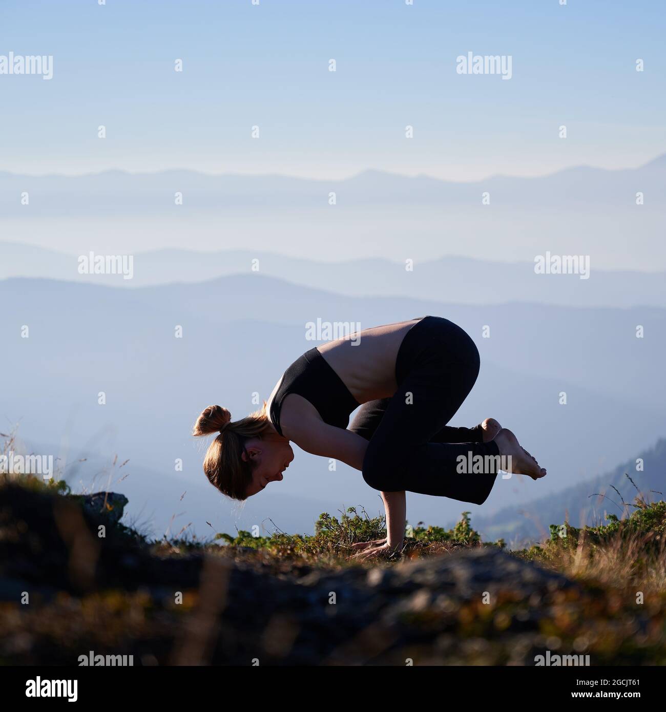 Side view of woman practicing yoga in Firefly pose. Meditating female ...