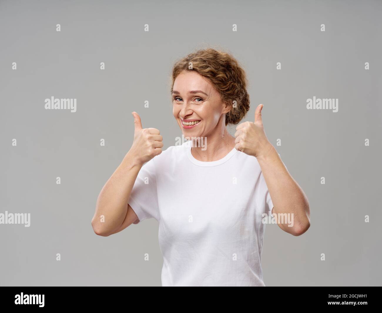 elderly woman in white t-shirt gestures with hands emotion studio Stock ...