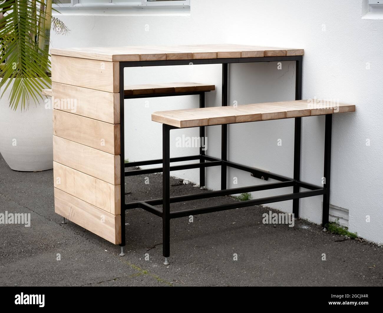 View of modern wooden outdoor cafe table at white wall Stock Photo - Alamy