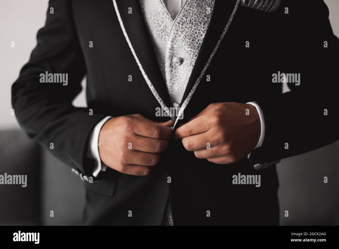 Crop unrecognizable man buttoning stylish elegant black groom jacket ...