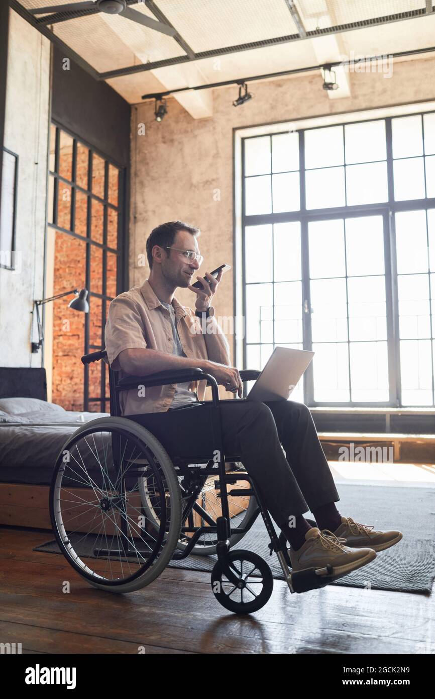 Vertical full length portrait of modern adult man in wheelchair ...