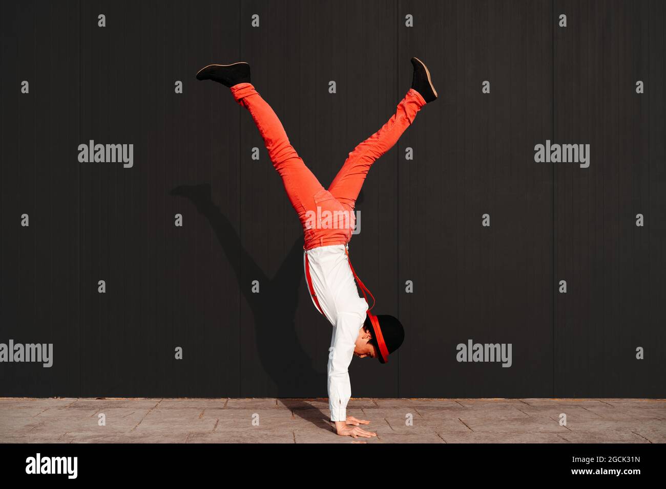 Side view of unrecognizable agile male circus performer doing handstand ...